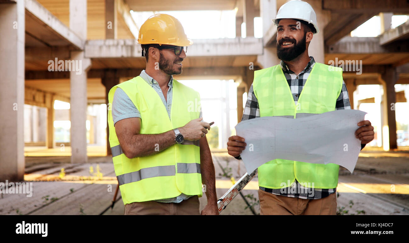 Team of construction engineers working on building site Stock Photo - Alamy
