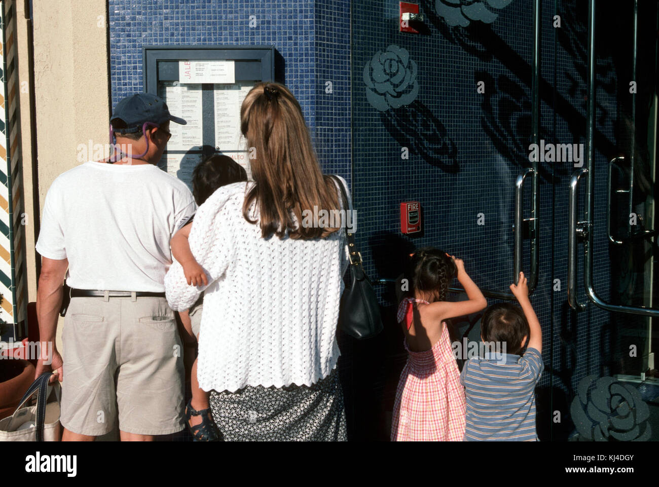 This image captures a family gathered around, reviewing a menu, likely ...