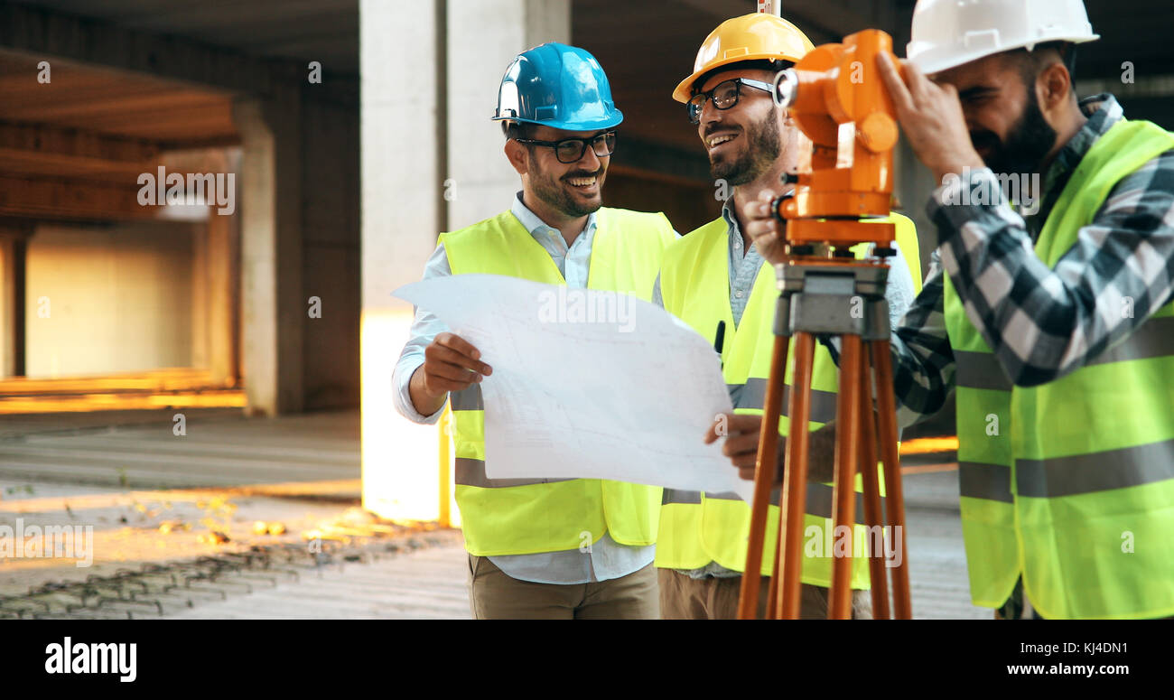 Team of construction engineers working on building site Stock Photo - Alamy