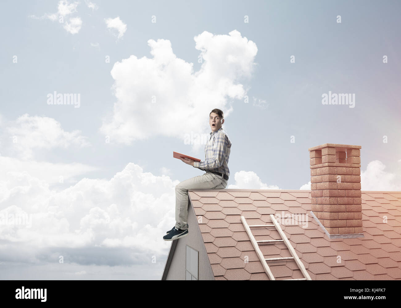 Handsome man on brick roof against cloud scape reading book Stock Photo ...