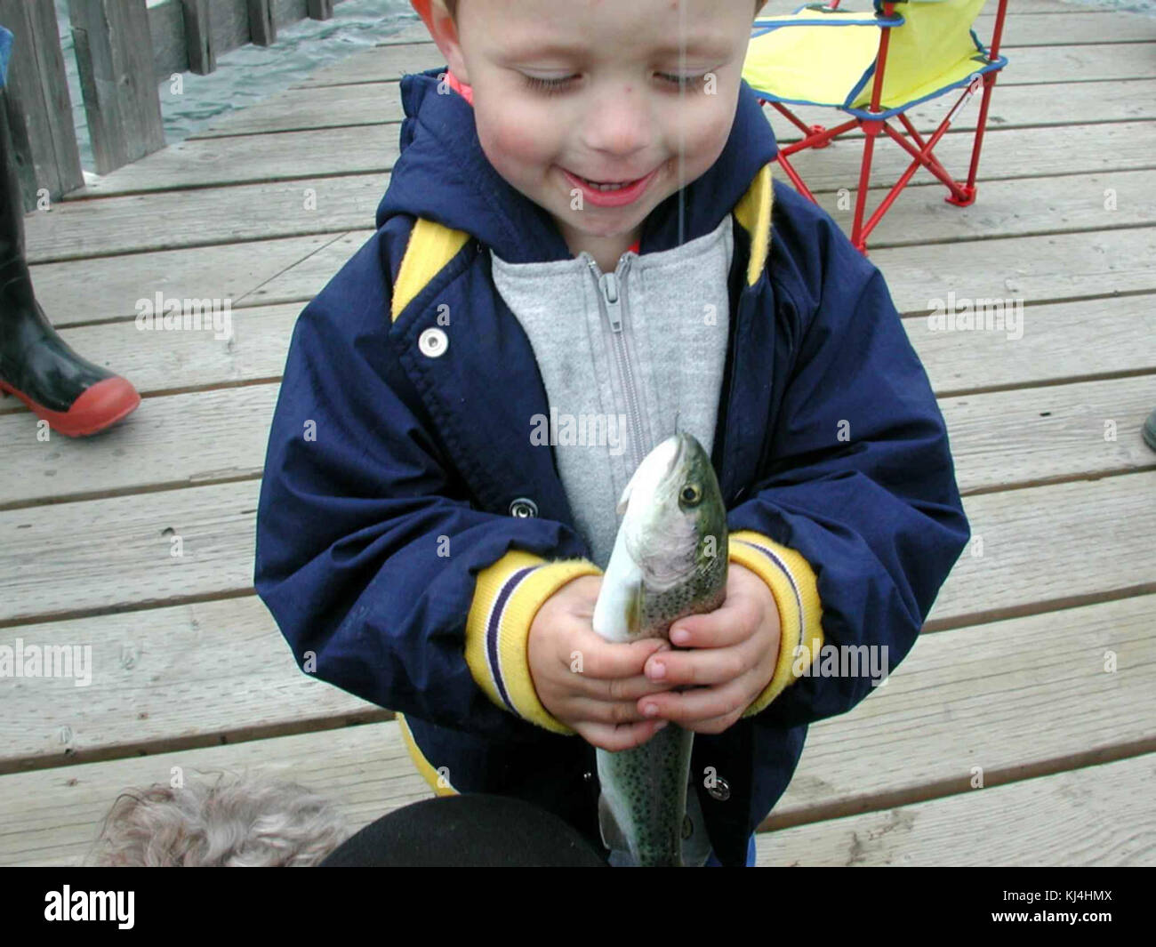Child holding fish on a pier Stock Photo - Alamy
