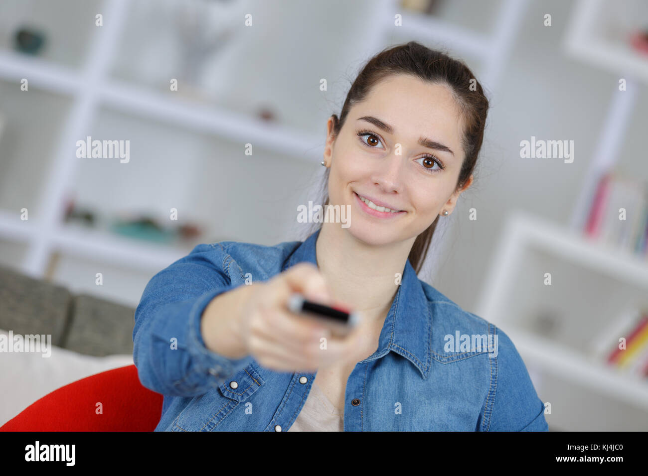 Young lady using remote control Stock Photo - Alamy