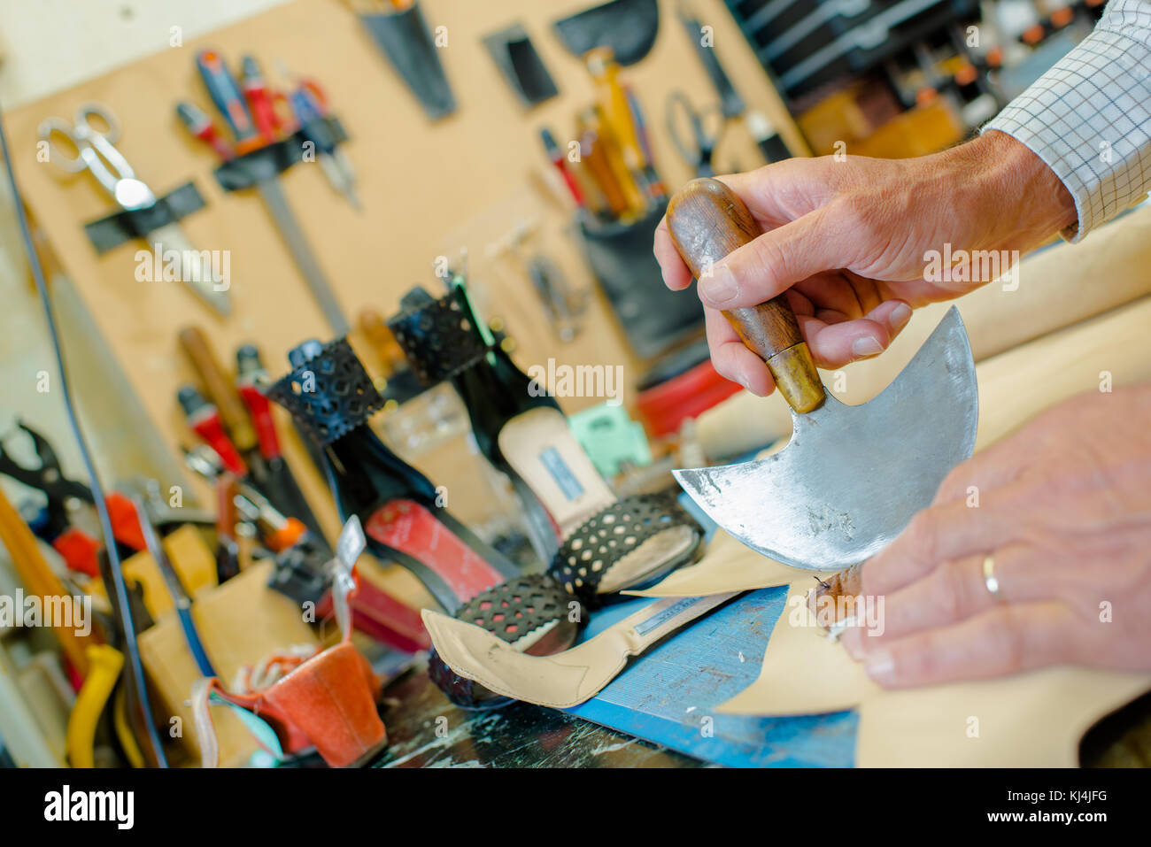 Shoe-repairer using a tool Stock Photo - Alamy