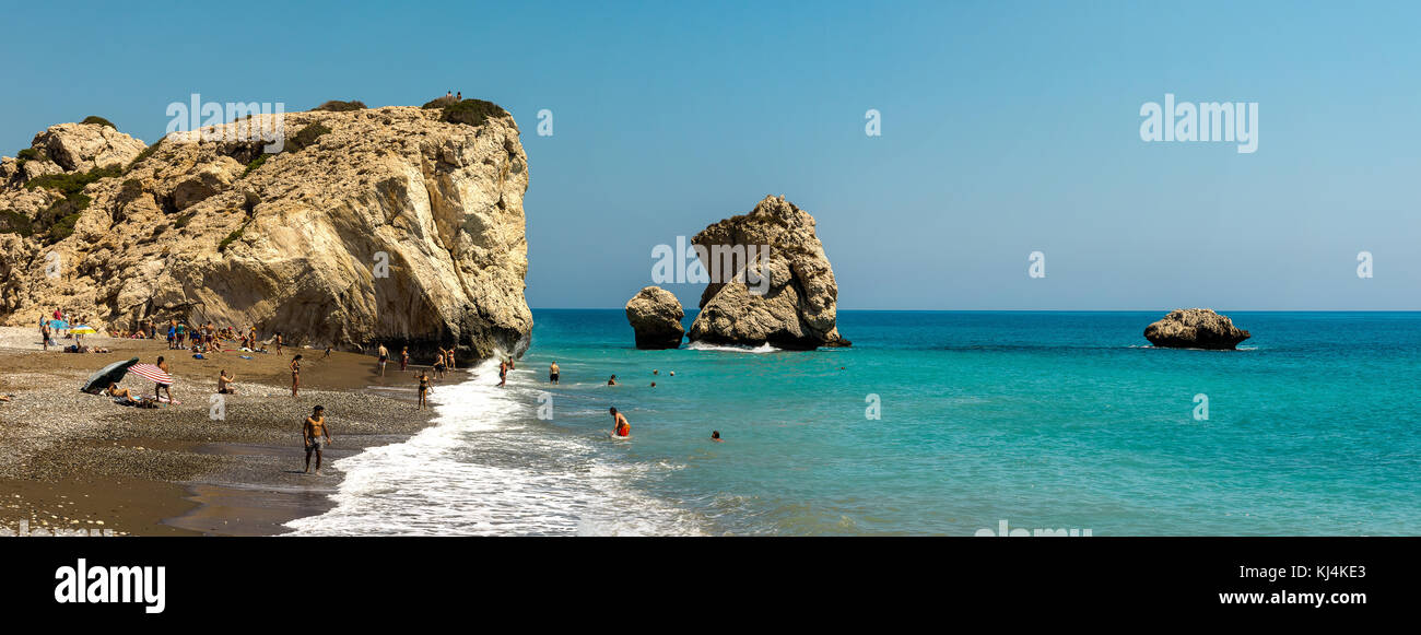 Tourists visiting Aphrodite Rock and swimming on a beach in Cyprus ...