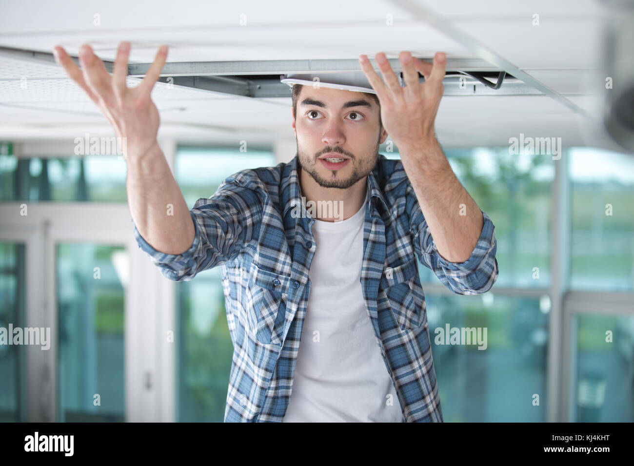 builder replacing ceiling panel Stock Photo - Alamy