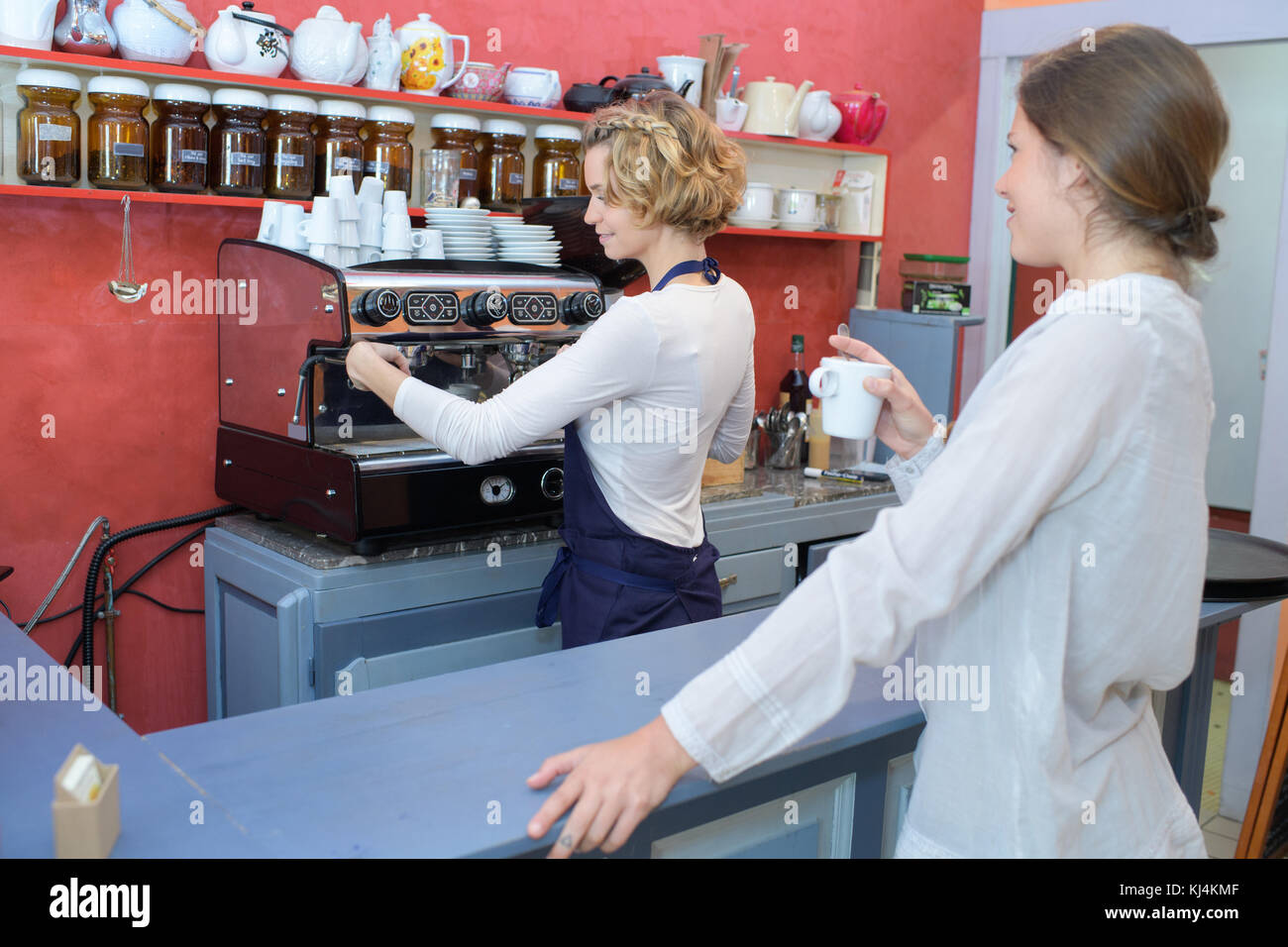 barista making coffee at the bar with female client Stock Photo - Alamy