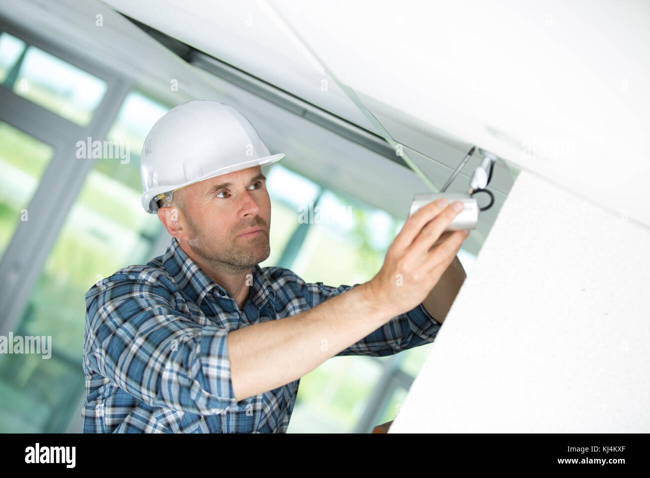 handsome technician installing security camera system in enterprise ...
