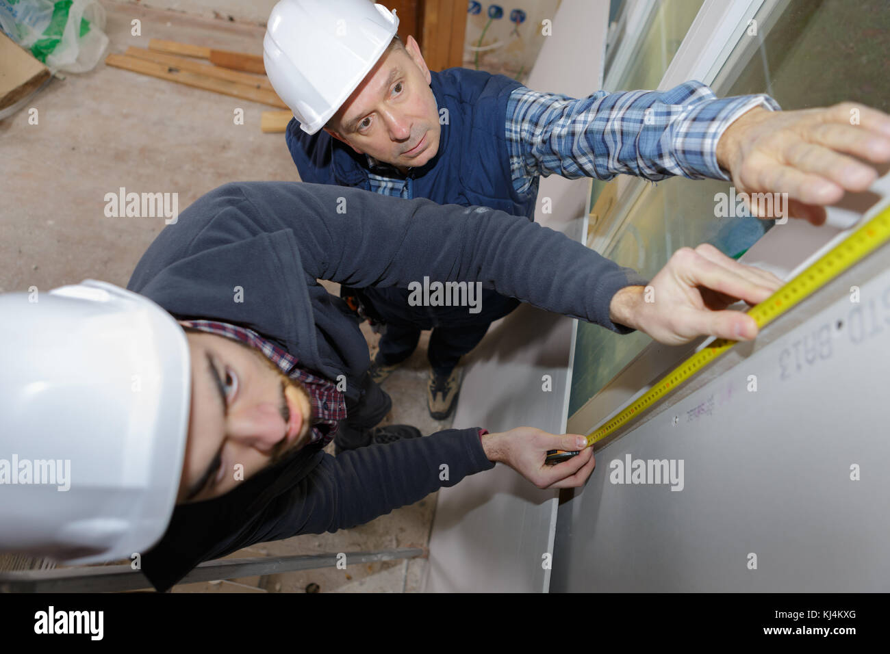 builder measuring the wall Stock Photo - Alamy