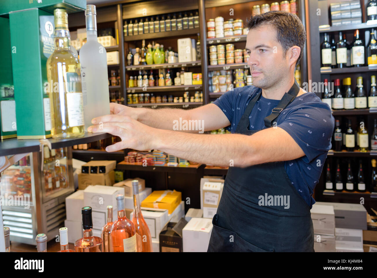 Man stacking bottle on shelf Stock Photo - Alamy