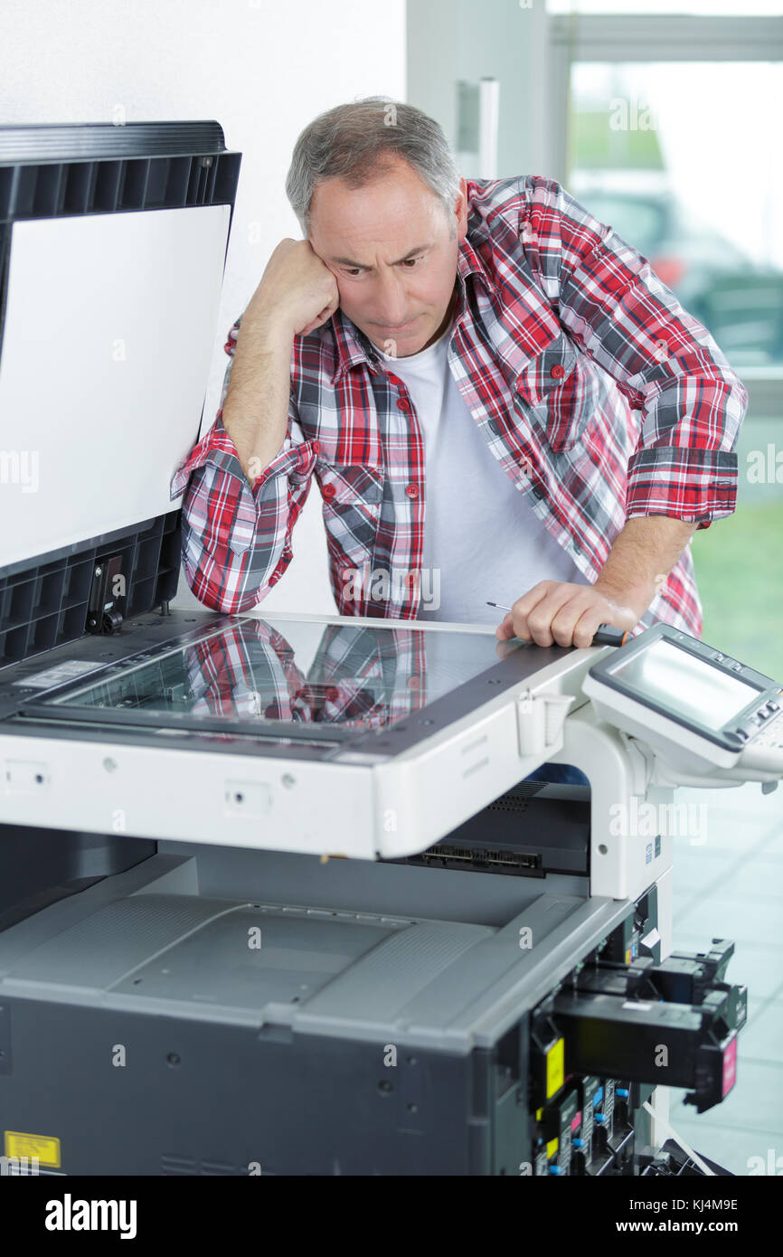confused worker fixing a printer Stock Photo - Alamy