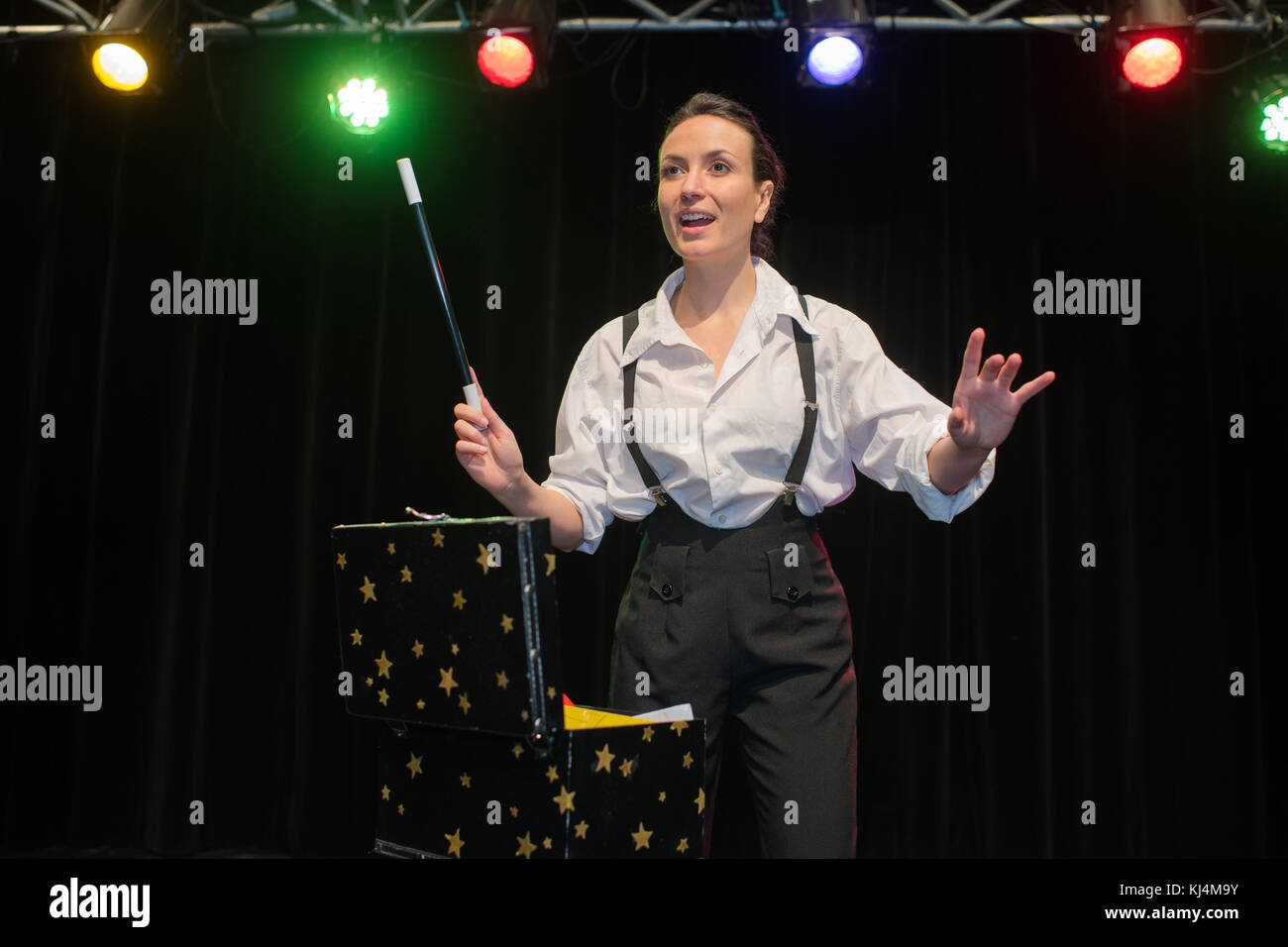 female magician performing her show on stage Stock Photo - Alamy
