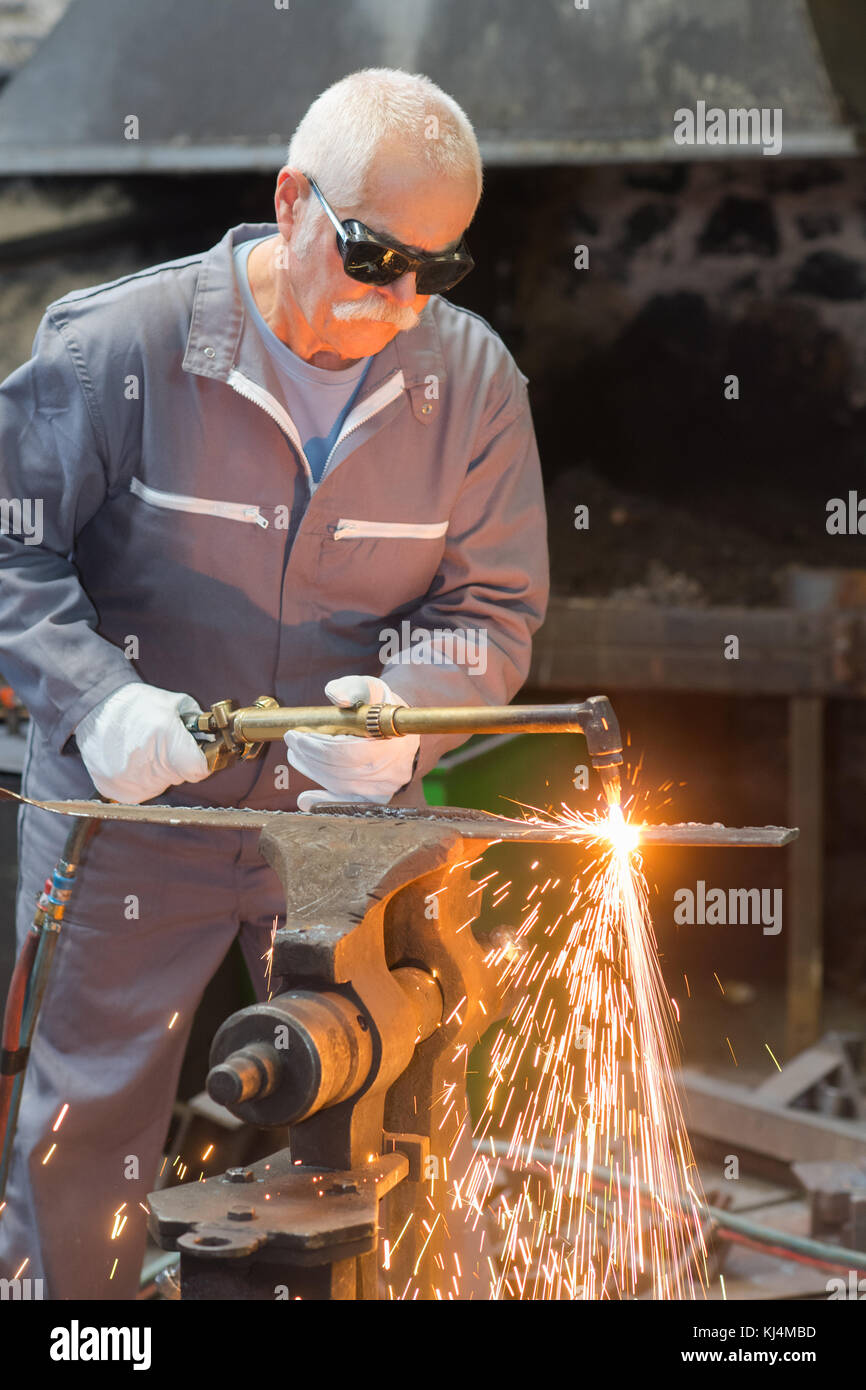 senior workman working with grinder producing flash of sparkles Stock ...