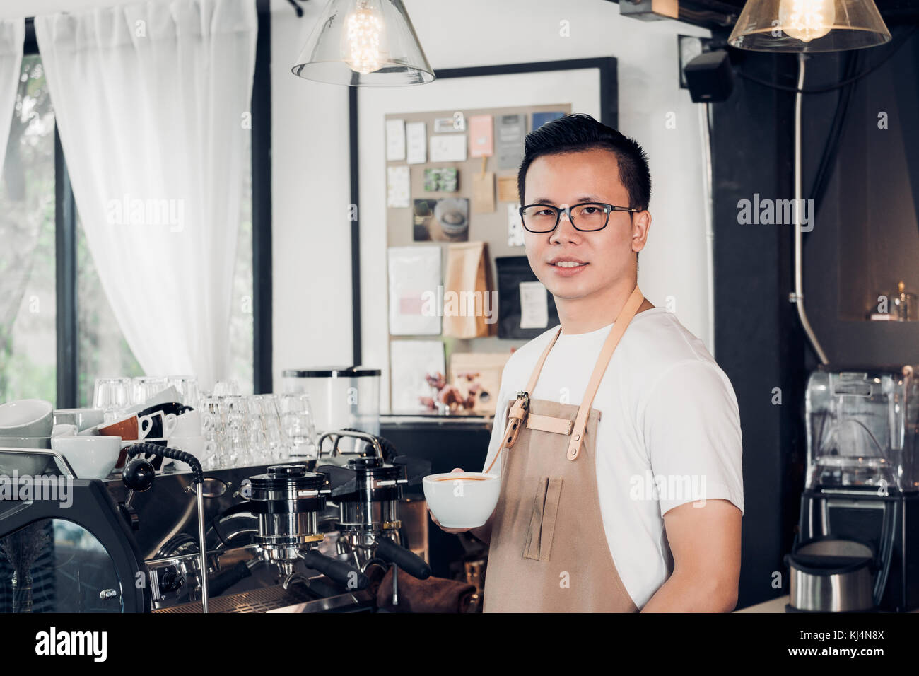 Male Barista cafe owner holding coffee cup in store counter bar inside ...