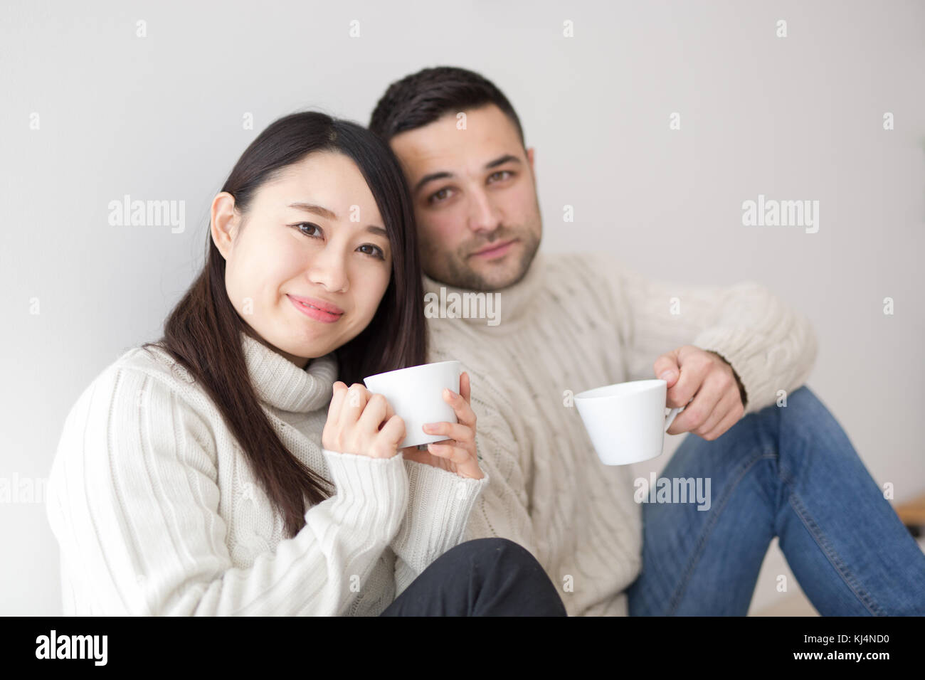 happy young multiethnic couple enjoying morning coffee by the window on ...