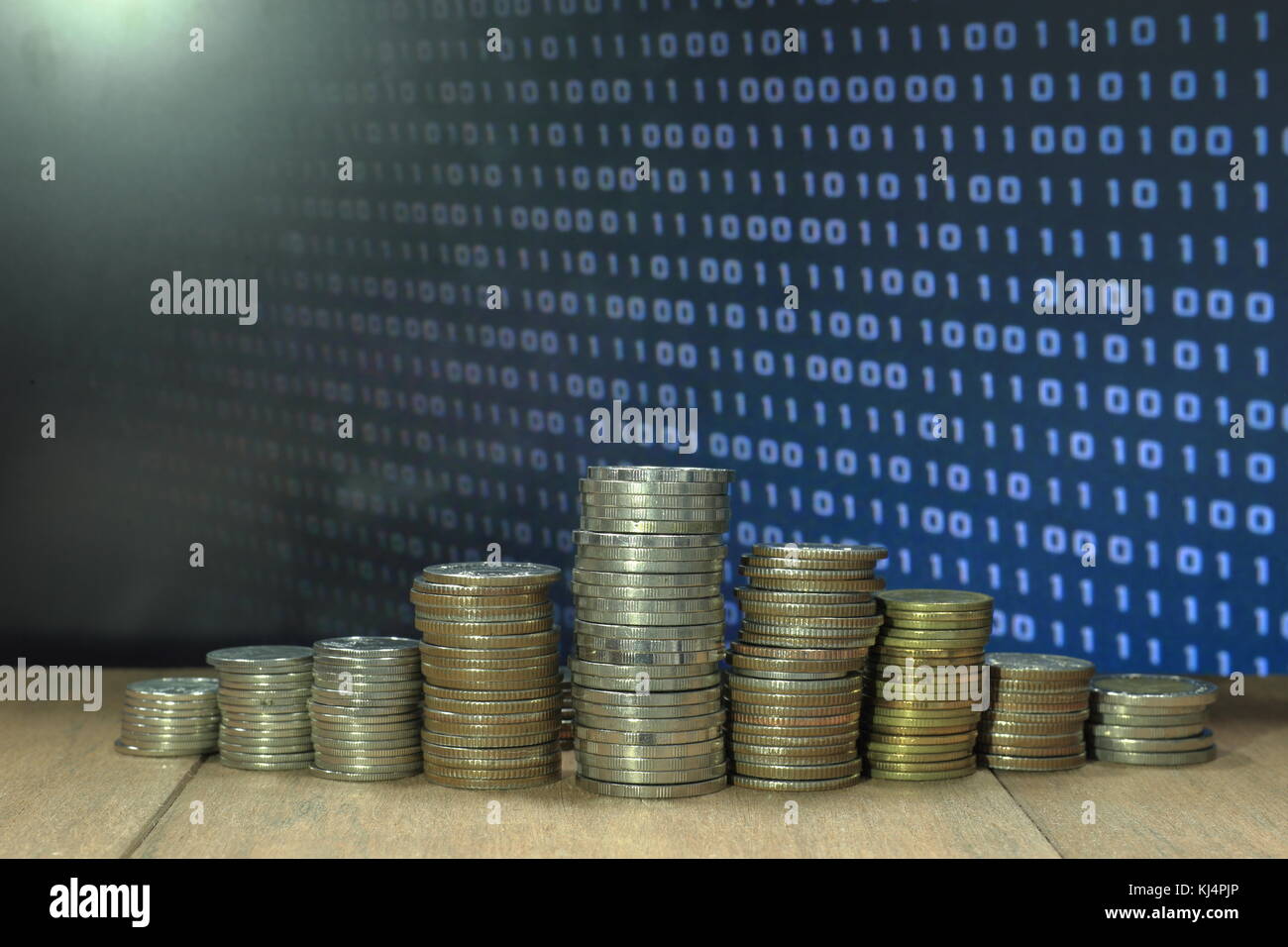 Digital economy. Coin stack pyramid shape with digital binary code in blue computer monitor ...