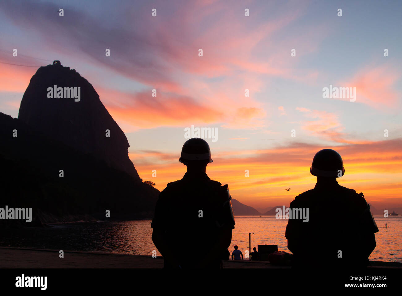 Guards from the army enjoying the sunrise at Praia Vermelha with ...