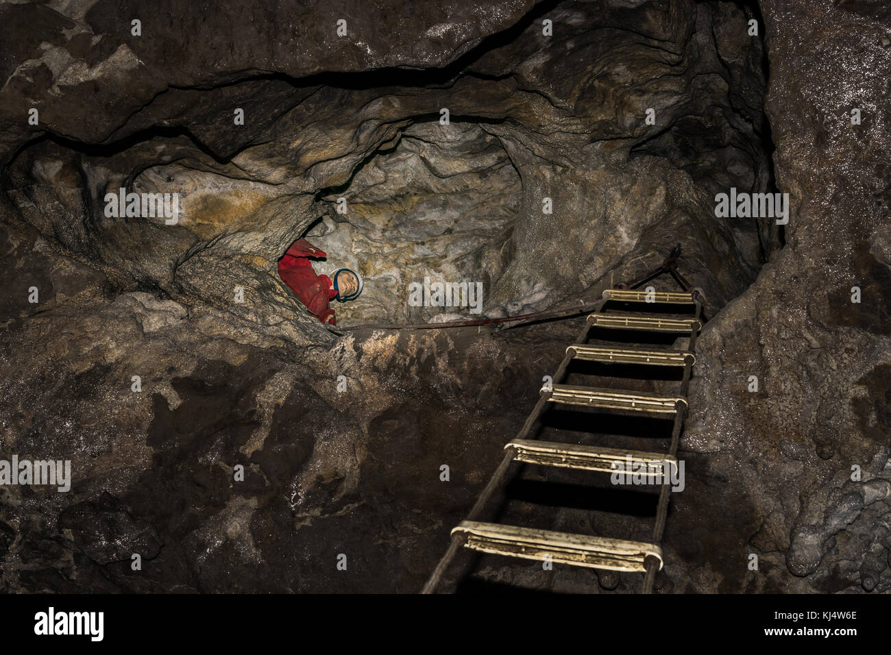 Cave explorer up in the hole with ladder Stock Photo - Alamy