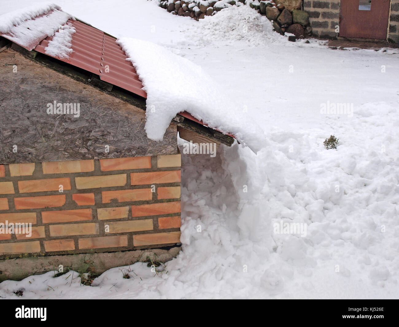 Wet melting snow slides down from metal well roof Stock Photo - Alamy