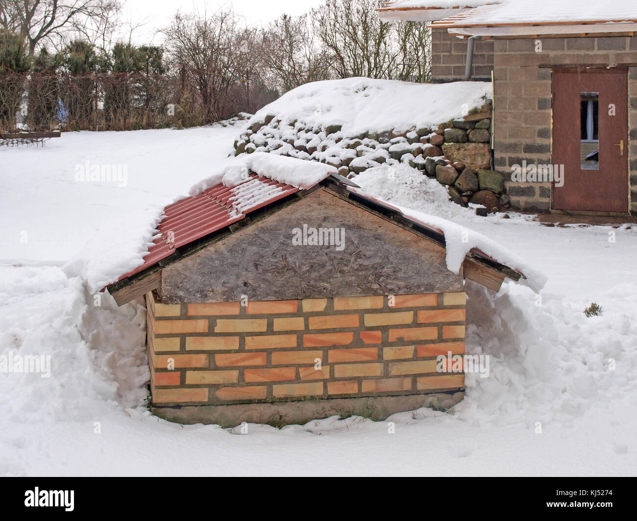 Wet melting snow slides down from metal well roof Stock Photo - Alamy