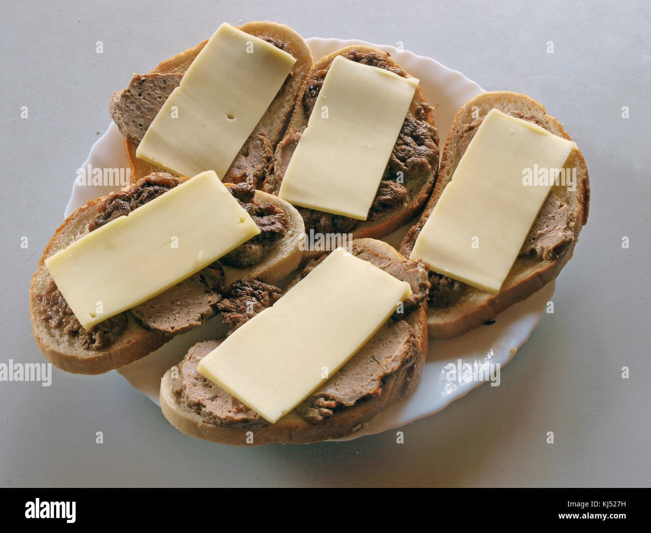 Sliced bread with meat and cheese on white dish close up Stock Photo ...