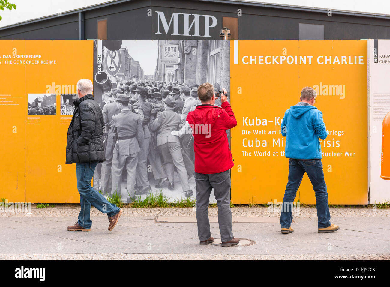 Berlin Wall Museum, tourists look at a photographic display on the wall ...