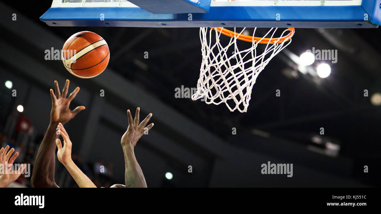 scoring during a basketball game - ball in hoop Stock Photo - Alamy