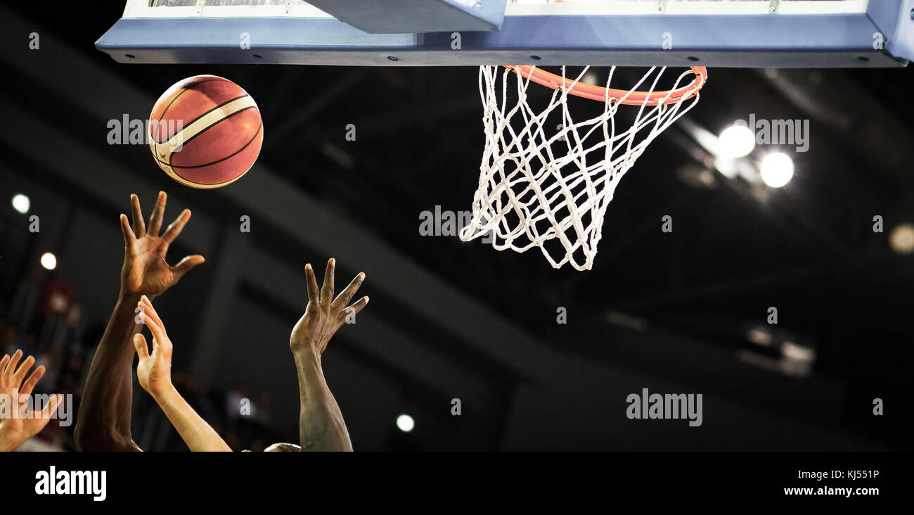 scoring during a basketball game - ball in hoop Stock Photo - Alamy