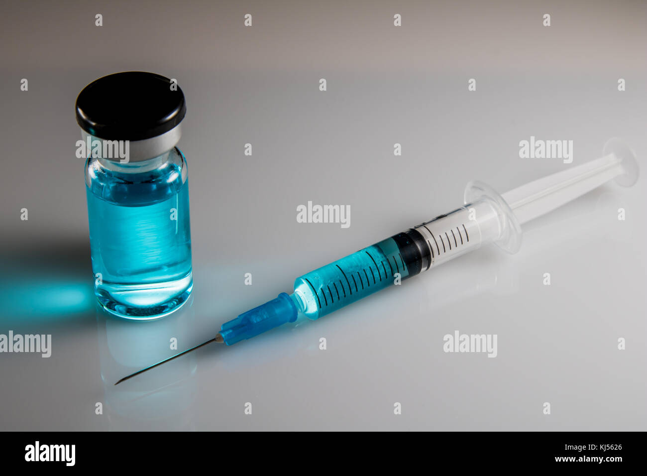 Medical syringe with blue liquid medicine Stock Photo - Alamy