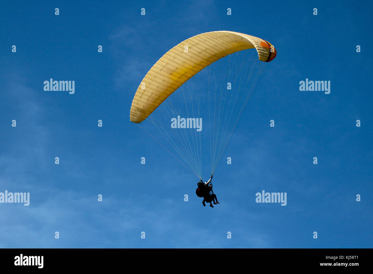 Paraglider flying in the blue sky against the background of clouds ...