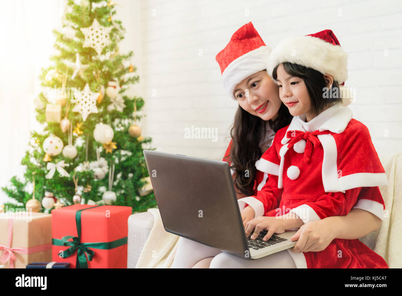 beautiful Asia Santa mother and cute little Asian kid using the ...
