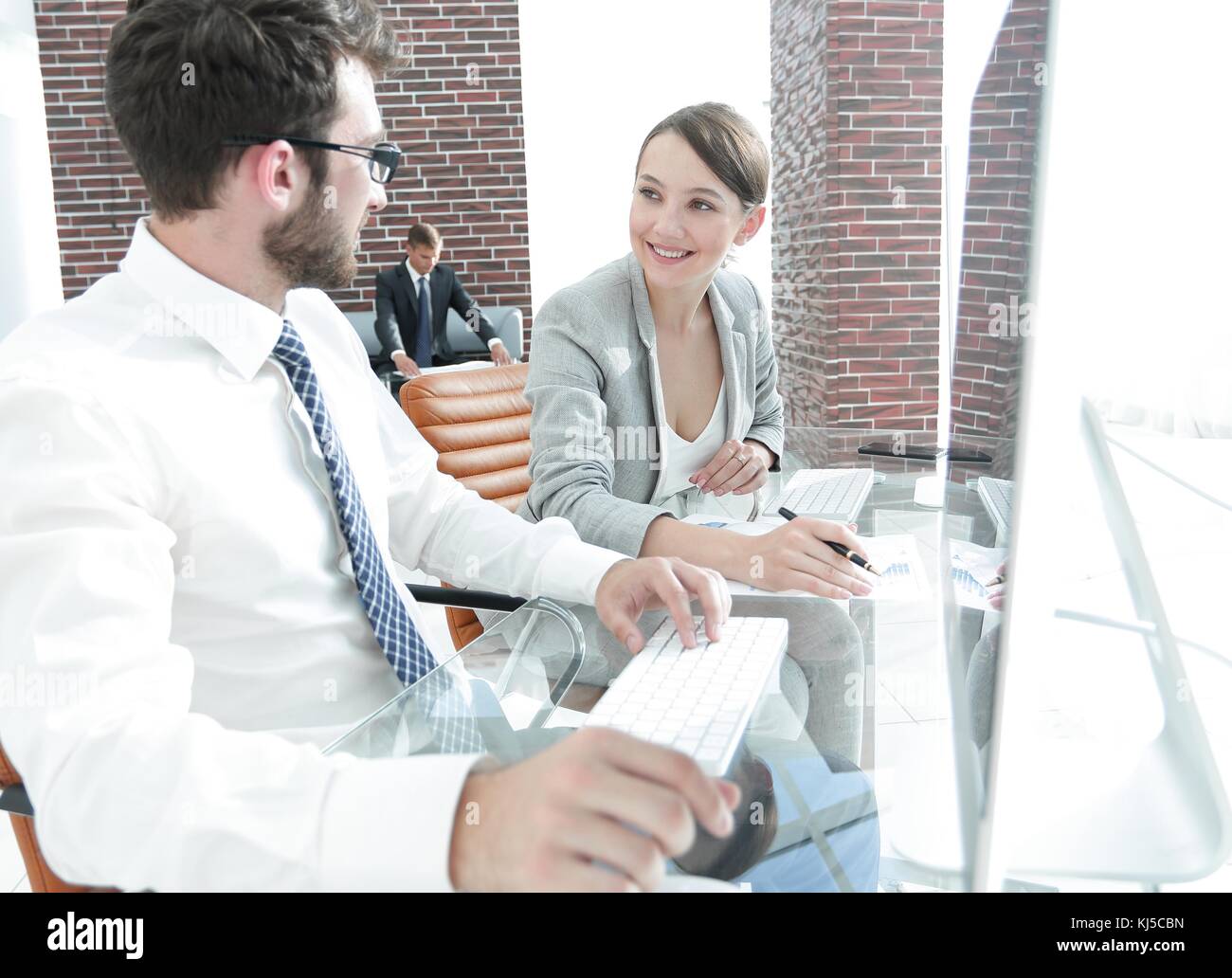 young professionals sitting behind a Desk Stock Photo - Alamy
