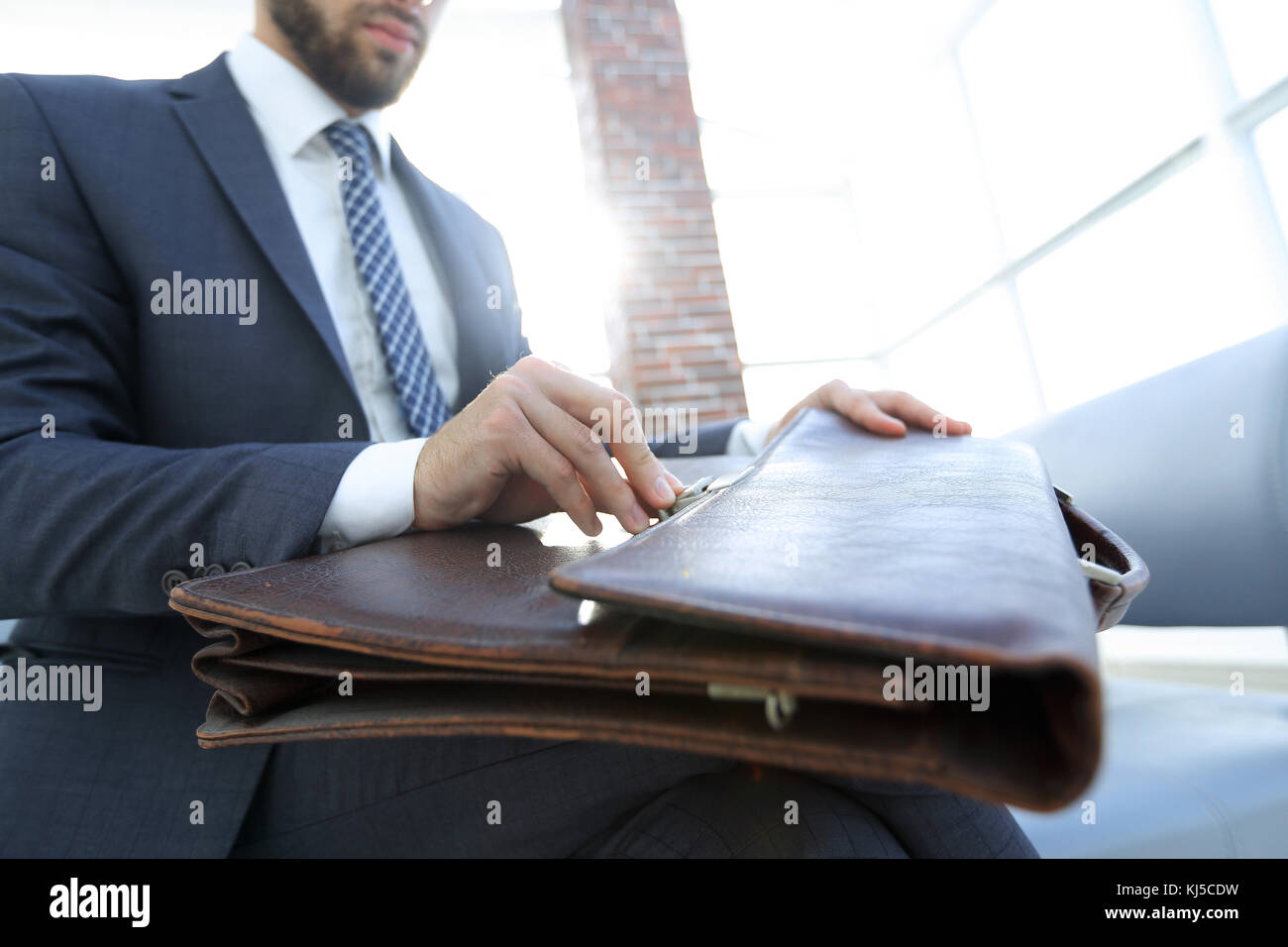 businessman's hand with suitecase in a modern office Stock Photo - Alamy