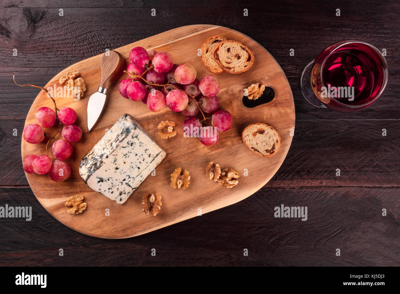 Blue cheese with grapes and vine on rustic textures Stock Photo - Alamy