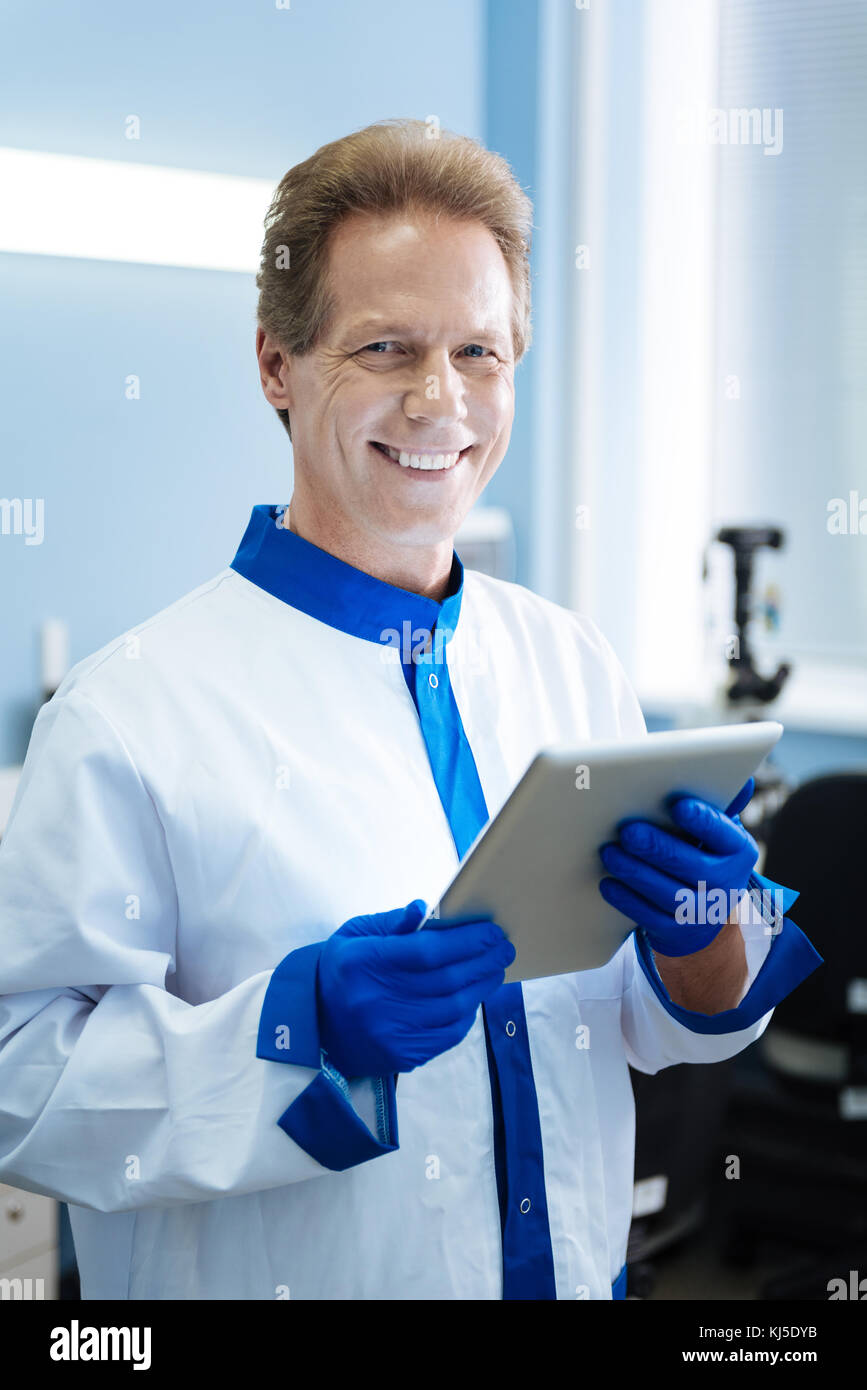 Inspired smiling scientist holding a tablet Stock Photo - Alamy