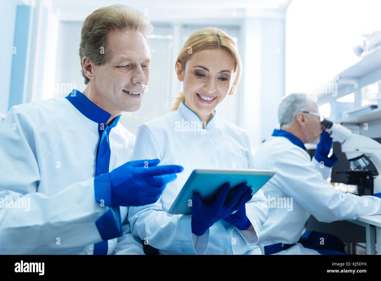 Exuberant researchers looking at the tablet Stock Photo - Alamy