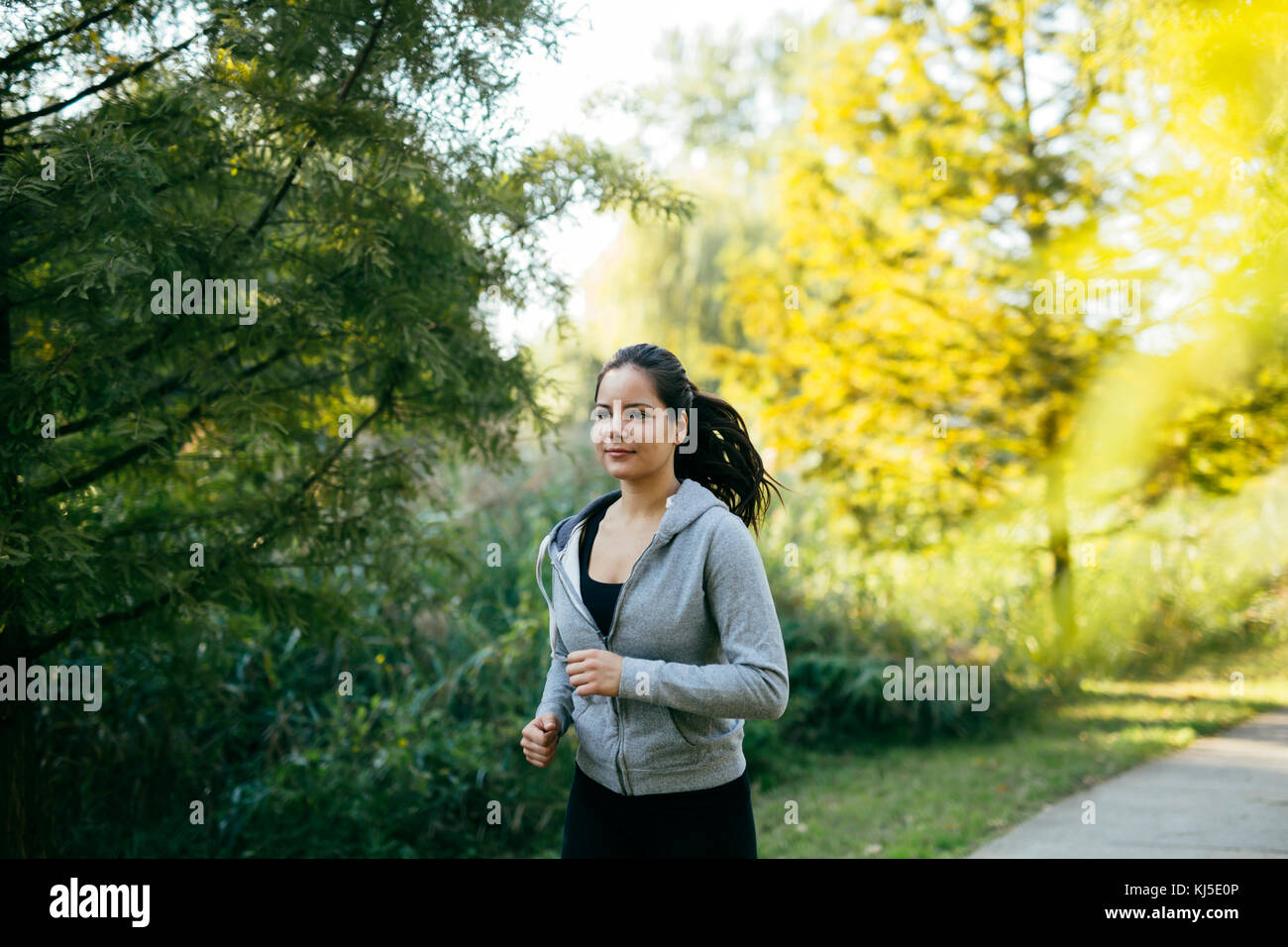 Fit beautiful woman jogging in park Stock Photo - Alamy