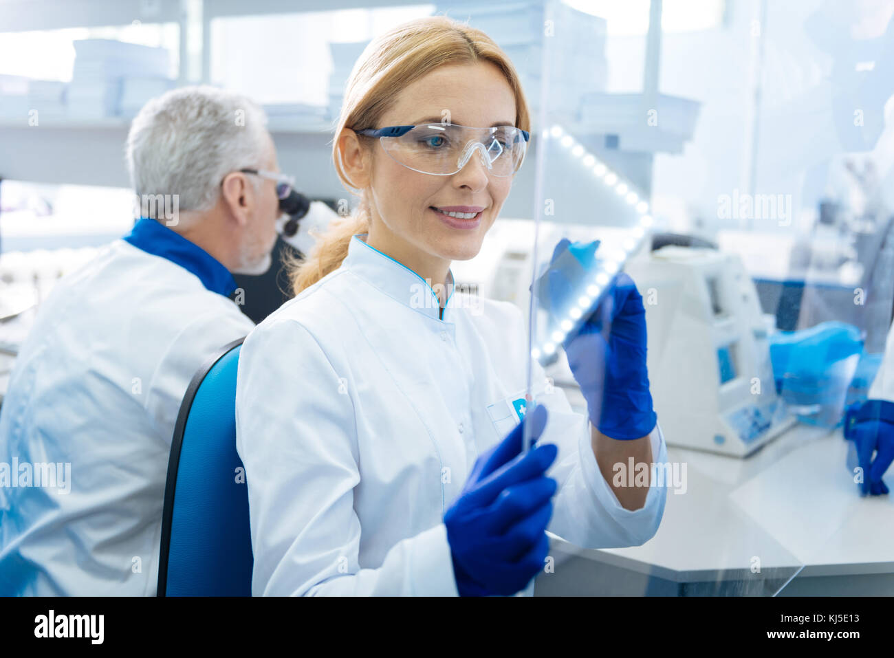 Smiling female researcher preparing for analysis Stock Photo - Alamy