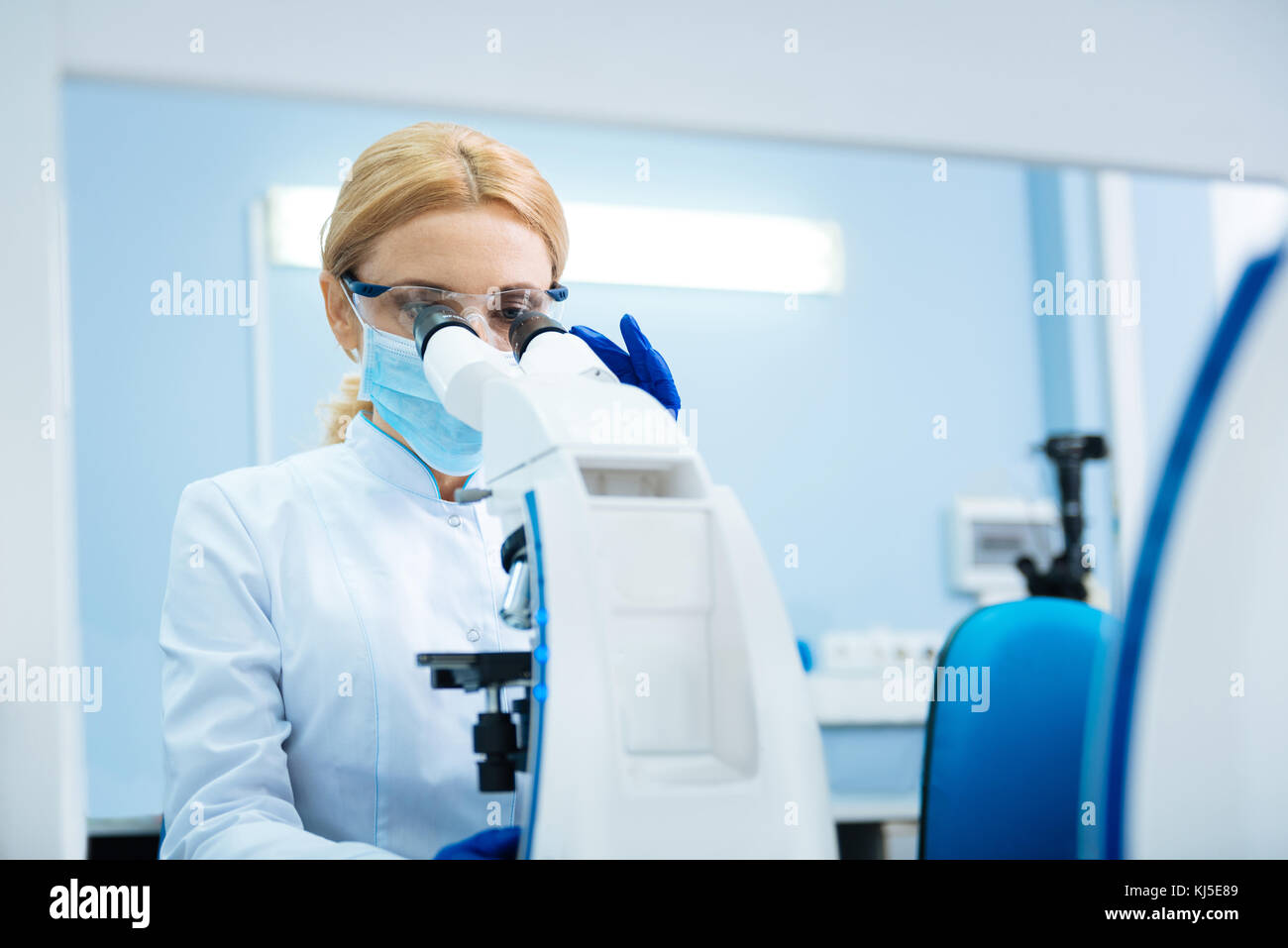 Promising researcher looking in the microscope in the lab Stock Photo ...