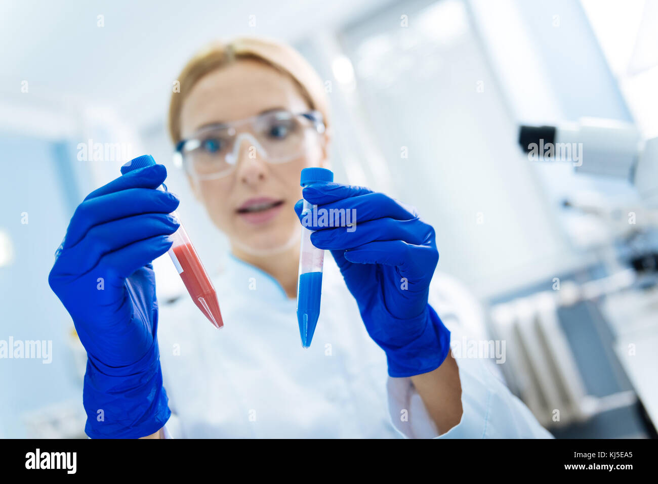 Determined scientist holding test tubes and wearing a uniform Stock ...