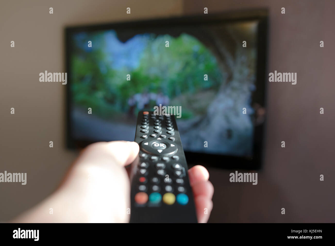 TV and hand hold remote control. Authentic day light Stock Photo - Alamy