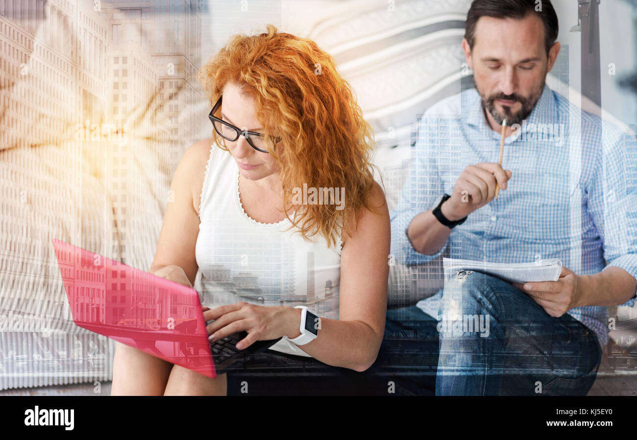 Busy young couple sitting at home together and working Stock Photo - Alamy