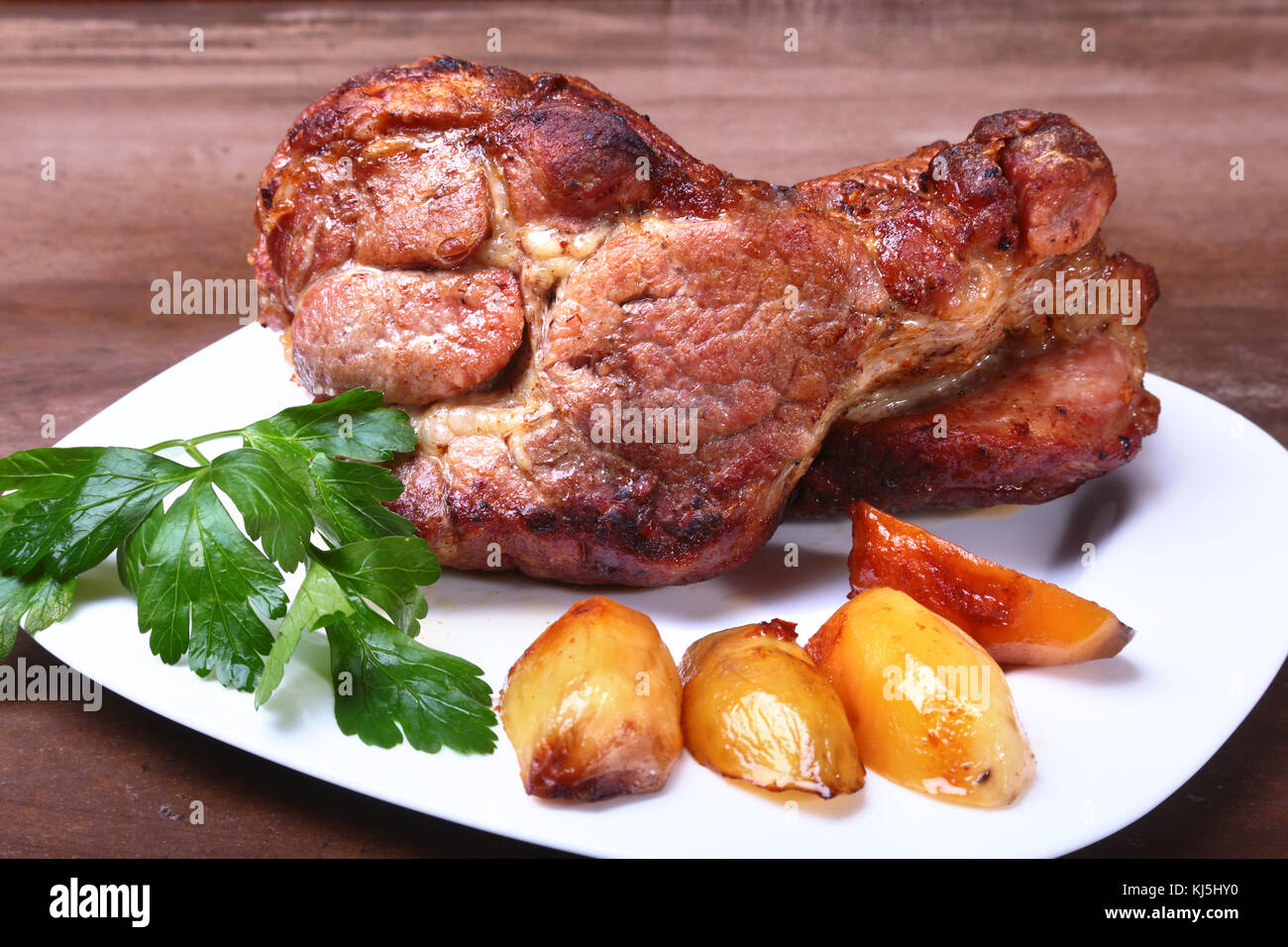 Juicy pork neck chops are grilled with potatoes on a white plate Stock ...
