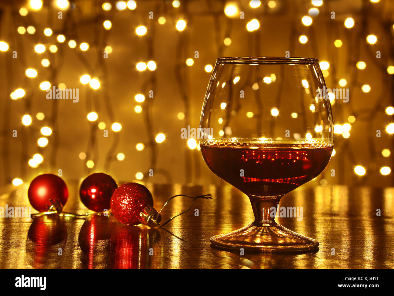 Christmas colorful balls and glass cognac or whiskey with defocused ...