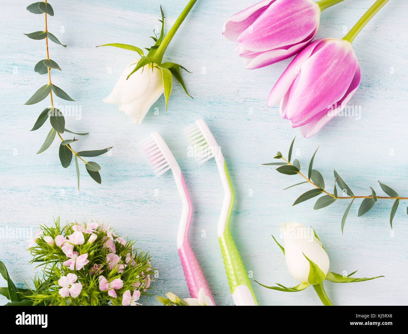 Two pastel toothbrushes with flowers herbs over green textured ... Two pastel toothbrushes with flowers herbs over green textured ...