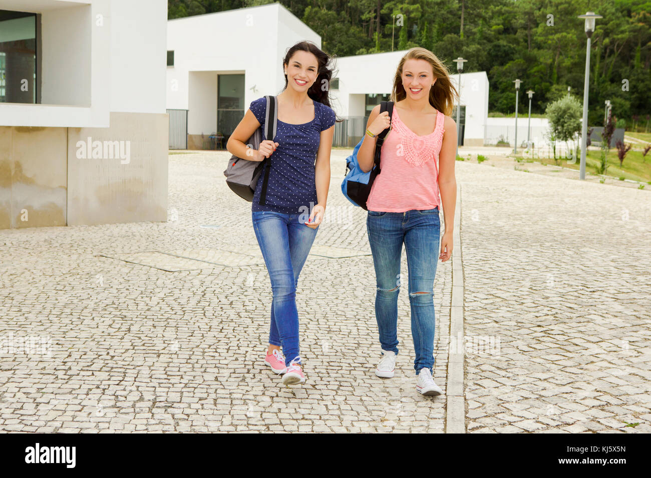 Two beautiful teenage students walking together in the school Stock ...