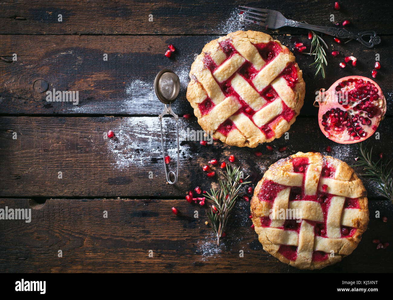 Couple of sweet tarts with pomegranate on wooden background with blank ...