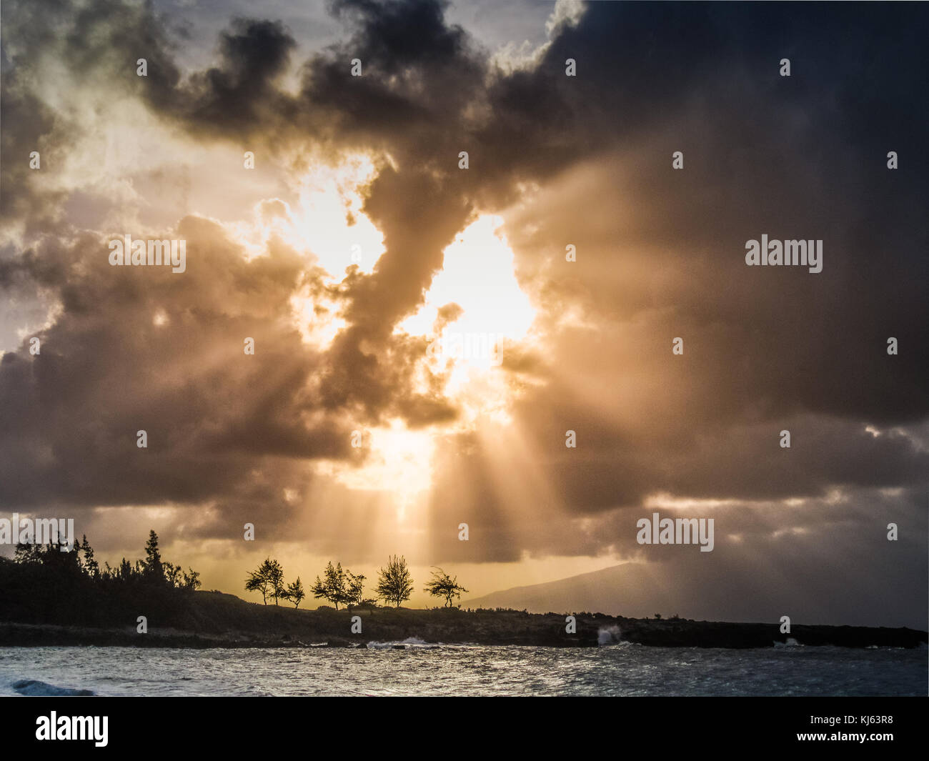 Beams of sunlight pushing through the clouds on the beach at D.T ...