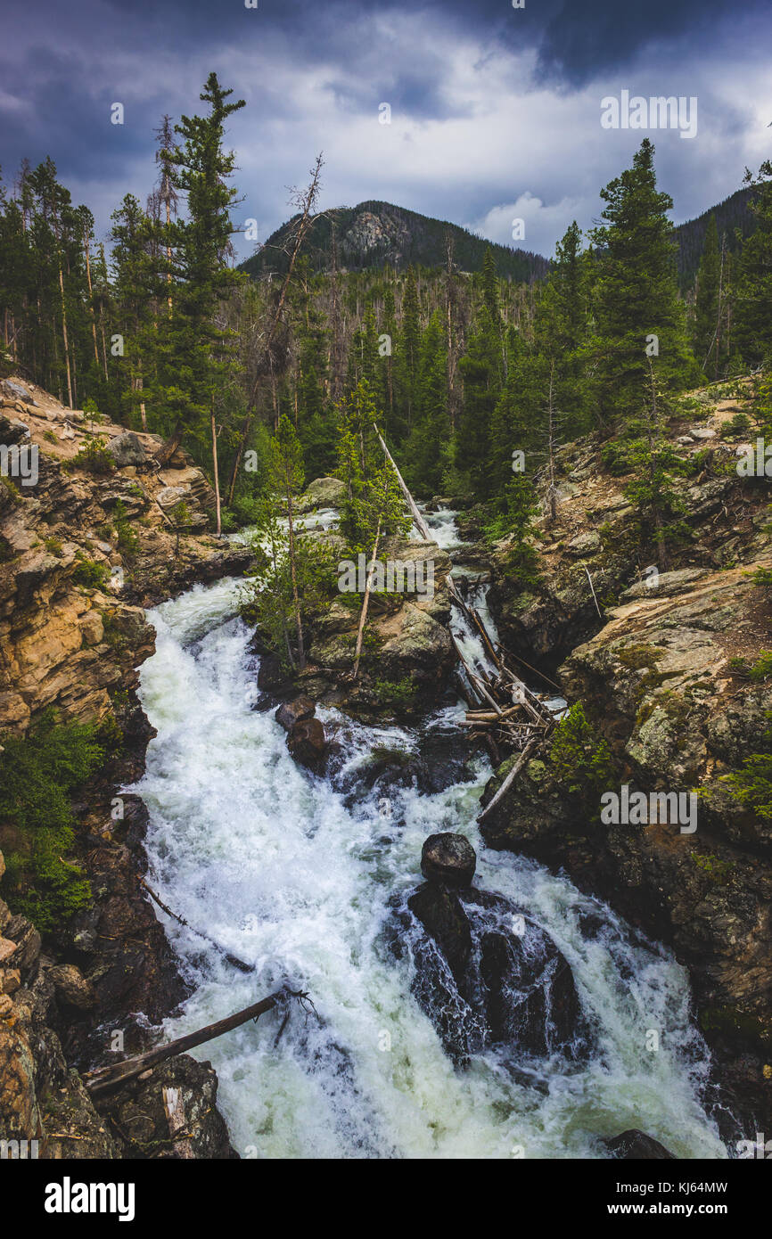 Adams Falls on a cloudy day with mountains and trees in the background ...