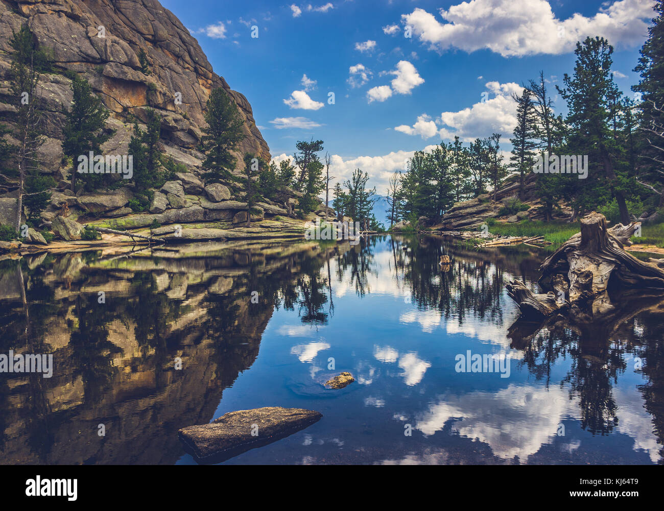 Calm water on Gem Lake creates a reflection of blue sky, clouds ...
