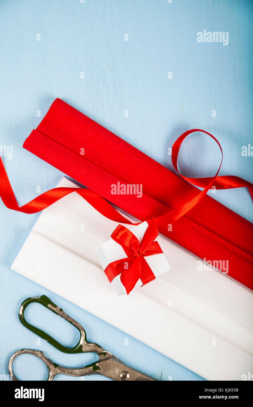 Packing of Christmas gifts. Ribbons, paper, scissors and ornaments on a ...